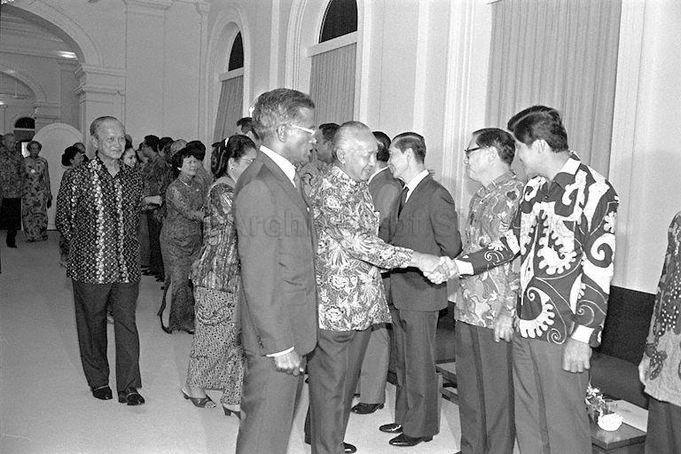 Indonesian President Suharto being greeted by an offical at