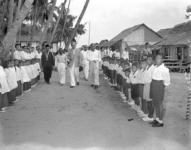 SCHOOL CHILDREN FORM TWO LINES TO WELCOME HIS EXCELLENCY,