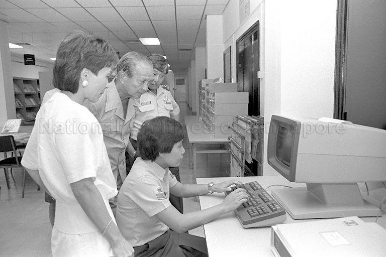 Looking intently at the computer with President Wee Kim Wee