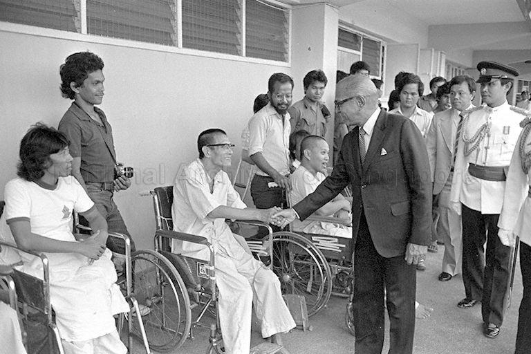 President Devan Nair meeting patients in wheelchairs after
