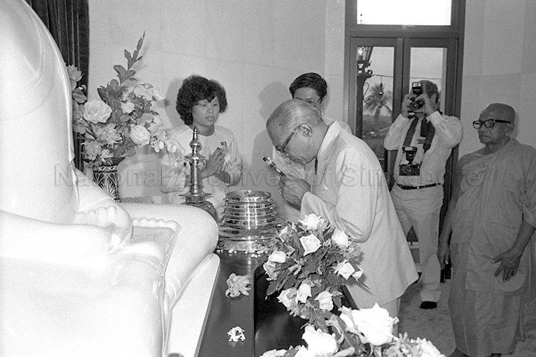 President C V Devan Nair using magnifying glass to see the