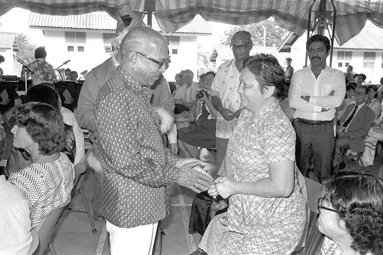 President C V Devan Nair distributing red packets to