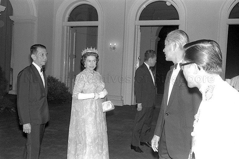 Queen Elizabeth II, accompanied by President Benjamin