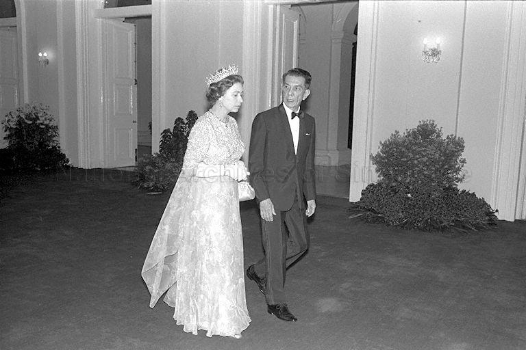 Queen Elizabeth II, accompanied by President Benjamin
