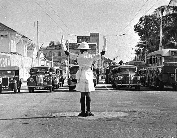 A TRAFFIC POLICEMAN GUIDING VEHICLES AT ROAD JUNCTION (POST-