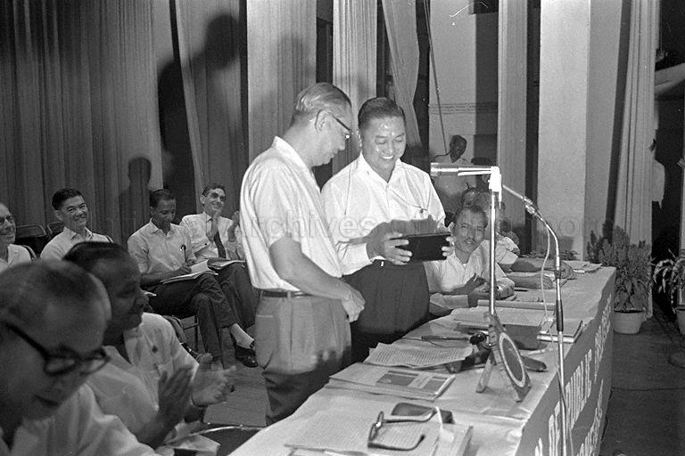 MINISTER FOR FINANCE LIM KIM SAN BEING PRESENTED WITH A GIFT