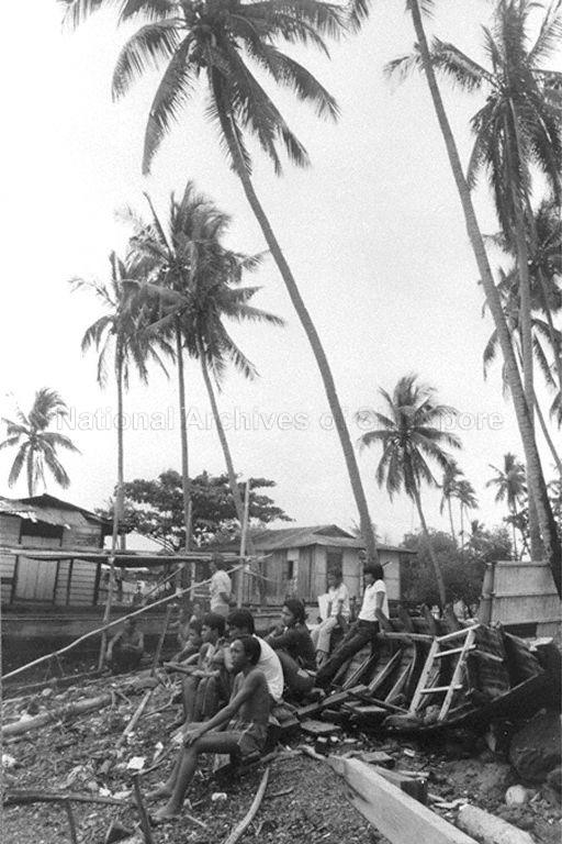 Young villagers with fishing boat at Malay kampong on Pulau