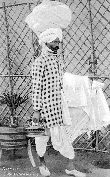 AN INDIAN WASHING MAN (DHOBI) WITH LAUNDRY AND CHARCOAL IRON