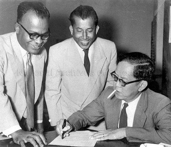 Chief Minister of Singapore Lim Yew Hock (right) signing a