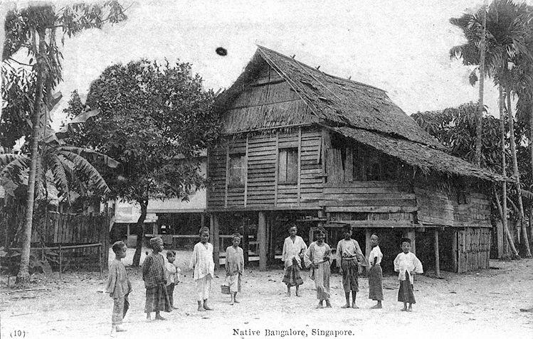 Malay boys posing outside Malay kampong or village house