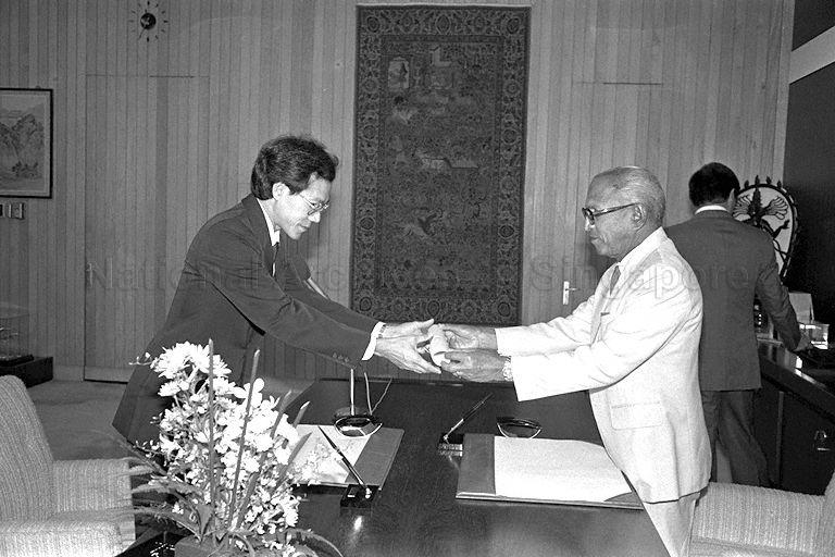 President C V Devan Nair (right) presenting the letter of