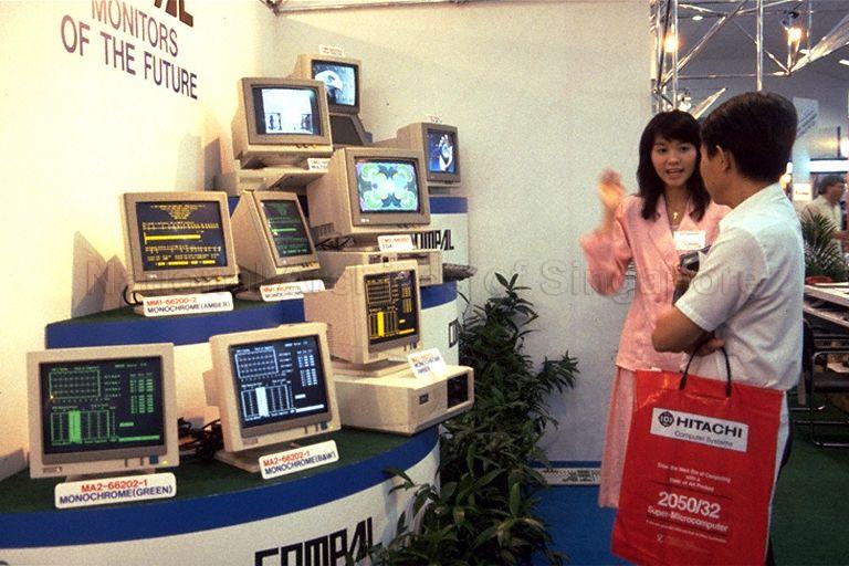 VISITORS LOOK AT COMPUTERS AT SINGAPORE INFORMATICS, WORLD