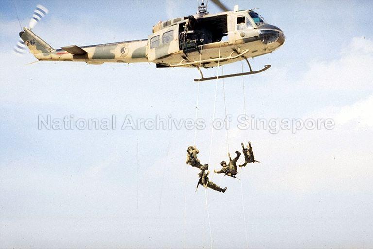Guardsmen rappelling from UH-1 helicopter at Singapore Armed