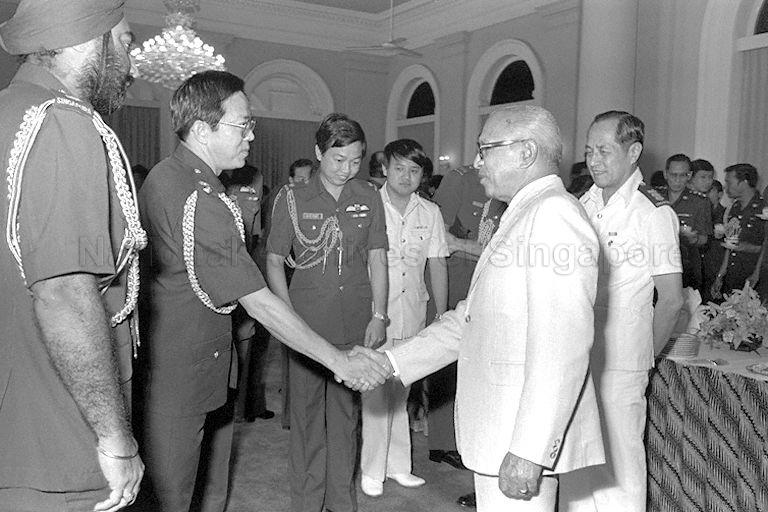 President Devan Nair shaking hands with an honorary aide-de-