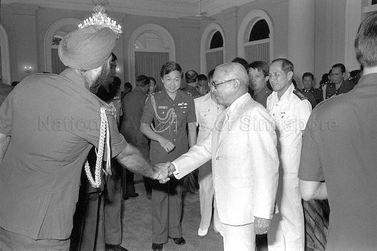 President Devan Nair shaking hands with an honorary aide-de-
