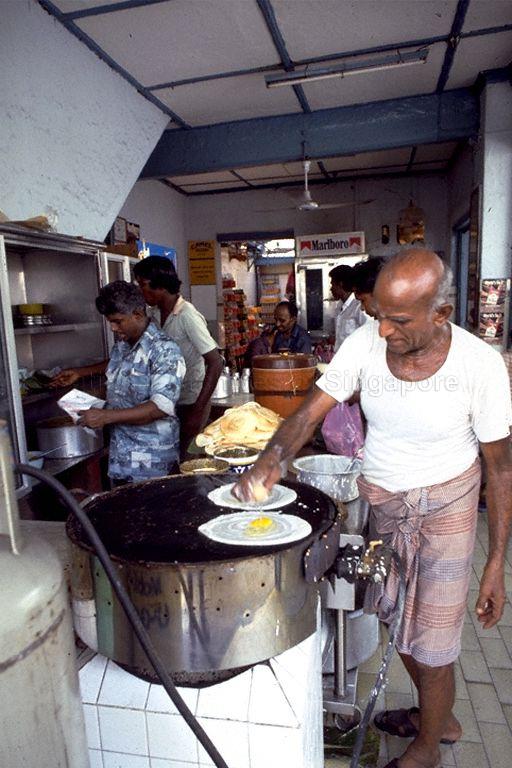 Man making roti prata in coffee shop in Serangoon Road area
