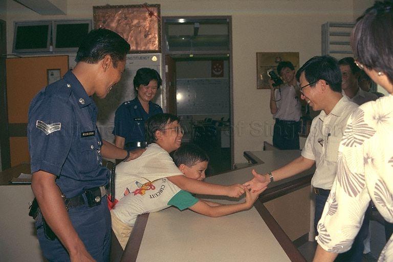 Adrian, 10, and Warren, 8, reaching out for the hand of