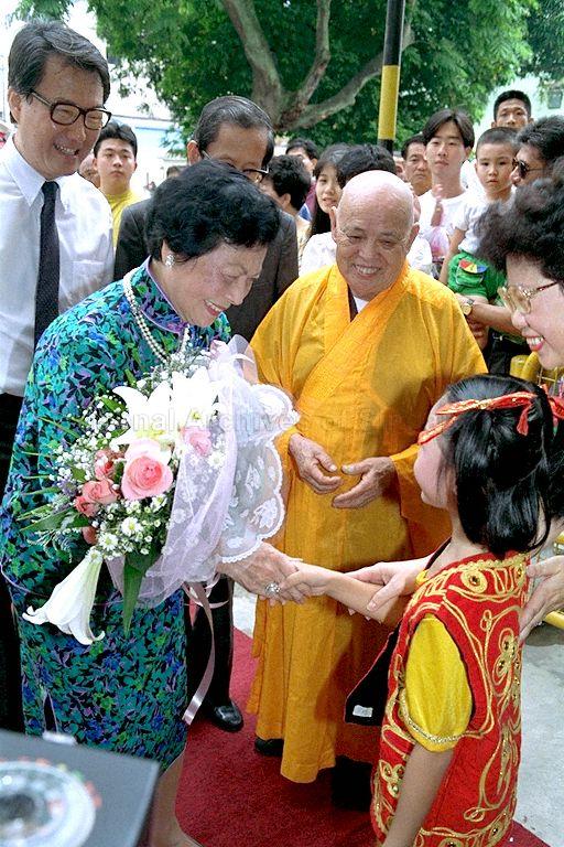 First Lady Mrs Wee Kim Wee is presented with a bouquet of