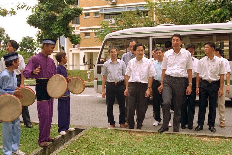 Members of Malay community playing kompang to welcome (front