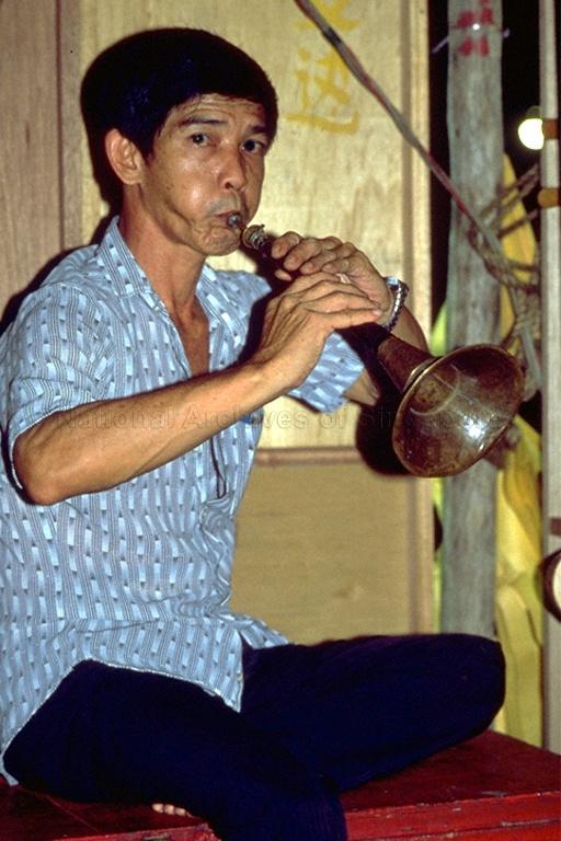 View of Chinese wayang (opera) musician playing a suona