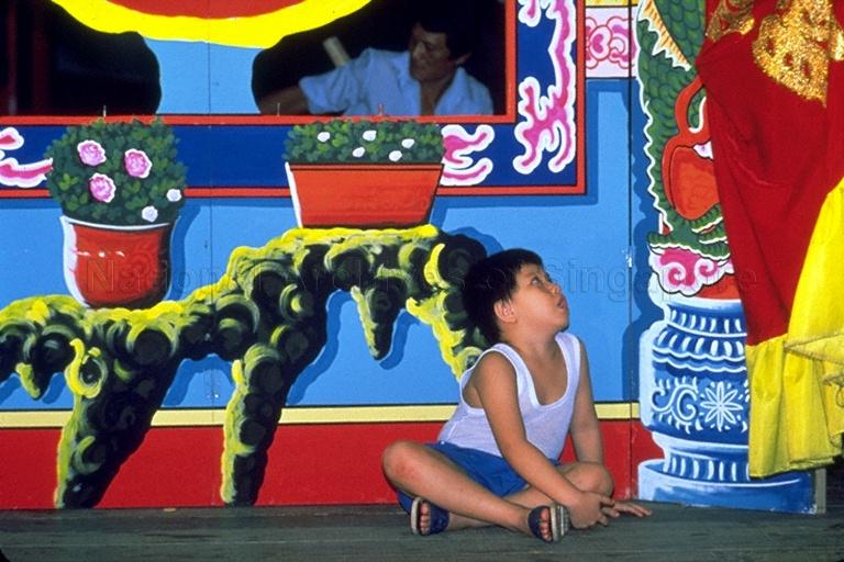 A child watching Chinese wayang (opera) performance. Behind