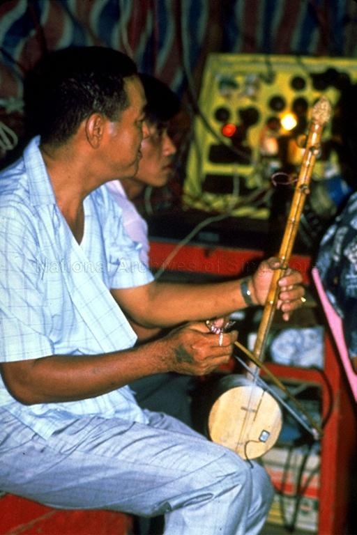 View of Chinese wayang (opera) musician playing a huqin