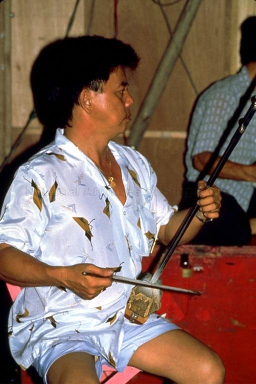 View of Chinese wayang (opera) musician playing the 'erhu'