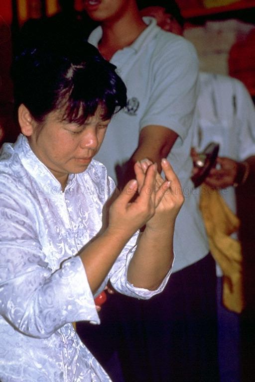 Medium (tangki) sitting on the 'dragon chair' in a Taoist