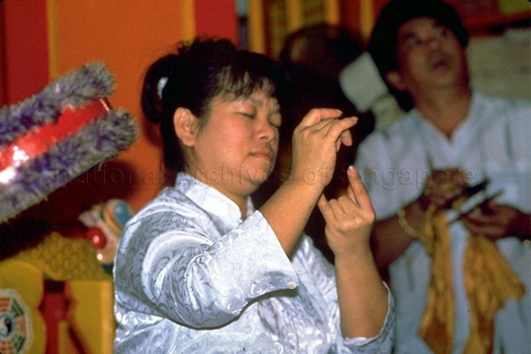 Medium (tangki) sitting on the 'dragon chair' in a Taoist