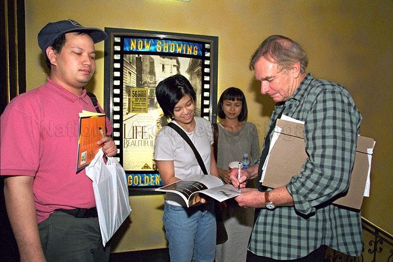 Australian director Peter Weir signing autograph for