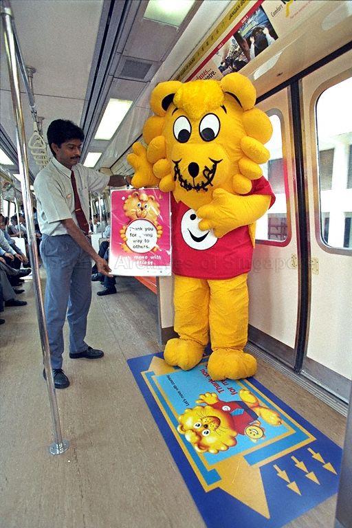 Singa the Courtesy Lion holding up sign encouraging train