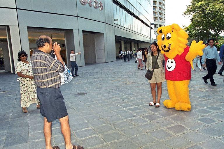 Singa the Courtesy Lion taking a picture with a passer-by