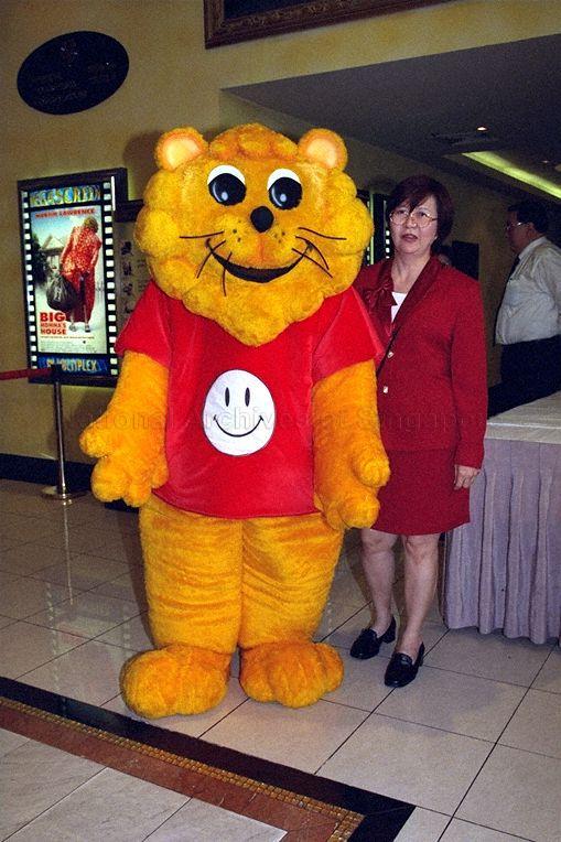 Official posing for photograph with Singa the Courtesy Lion