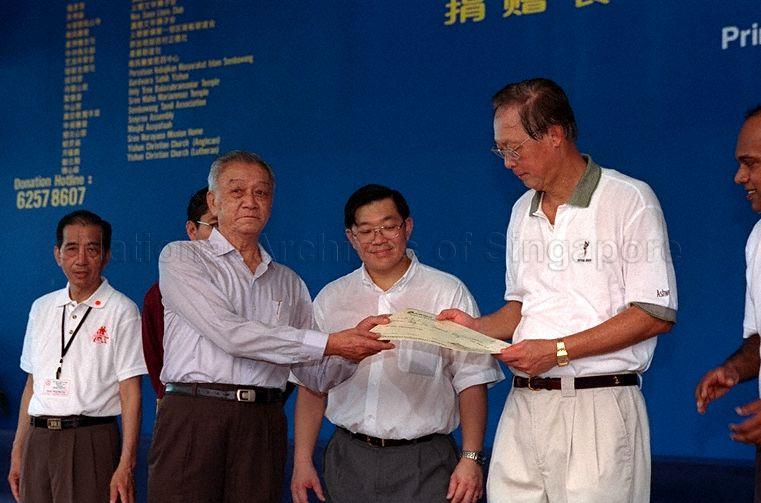 Prime Minister Goh Chok Tong giving away food ration and