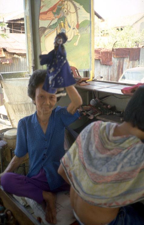 Backstage -- Puppeteer raising her glove puppet to pose for
