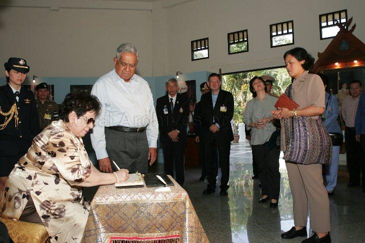 PICTURE SHOWS MRS S R NATHAN SIGNING THE GUEST BOOK WHILE