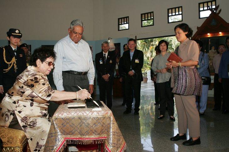 PICTURE SHOWS MRS S R NATHAN SIGNING THE GUEST BOOK WHILE