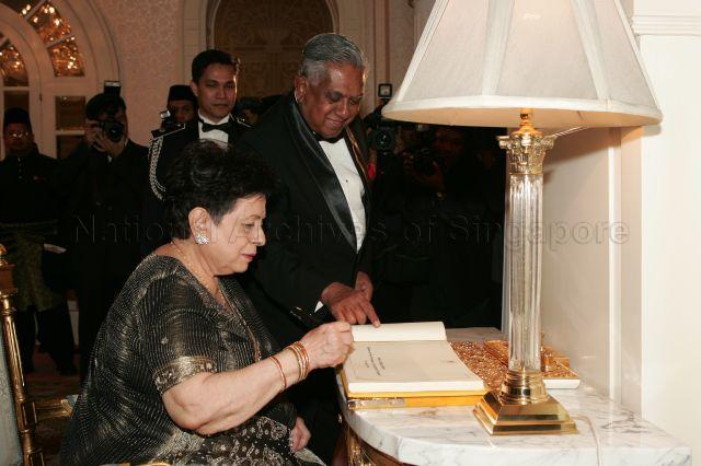 Mrs S R Nathan signing the guest book when she arrives to