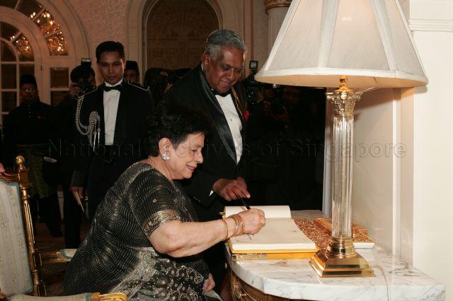 Mrs S R Nathan signing the guest book when she arrives to