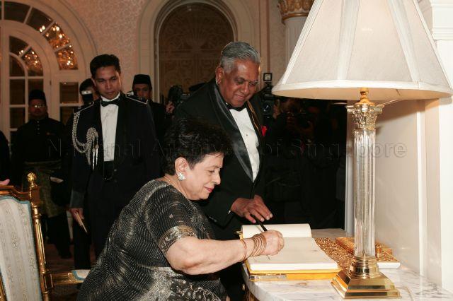 Mrs S R Nathan signing the guest book when she arrives to