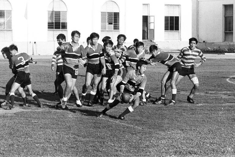 Raffles scrum-half, Ng Chee Fei, holding the ball during