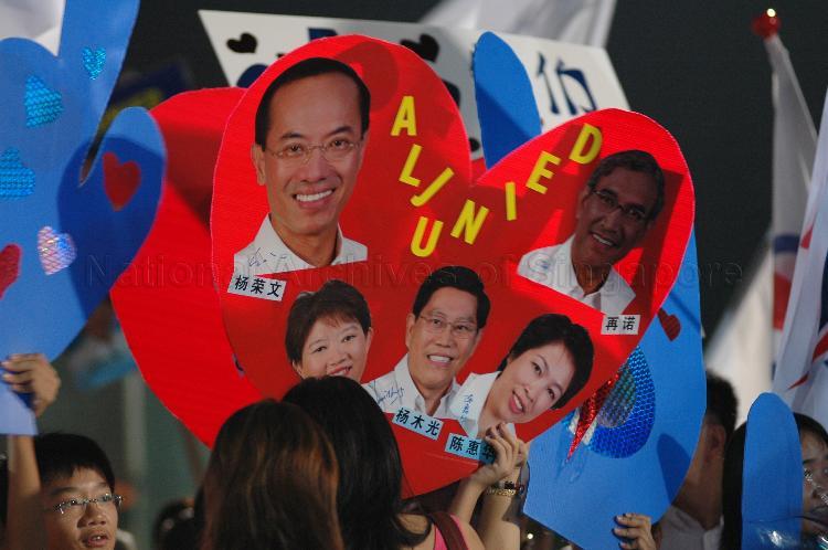 Supporters displaying handmade poster of People's Action