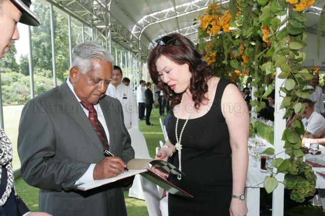President S R Nathan signing autograph for guest during