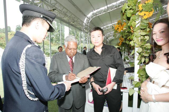 President S R Nathan signing autograph for guest during