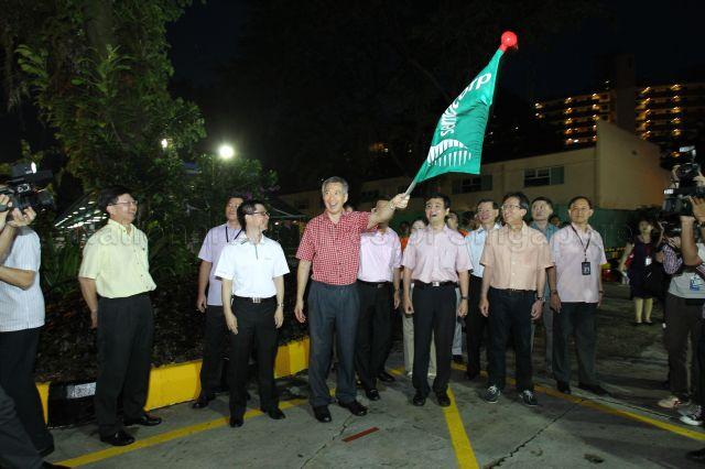Prime Minister Lee Hsien Loong flagging off trucks making