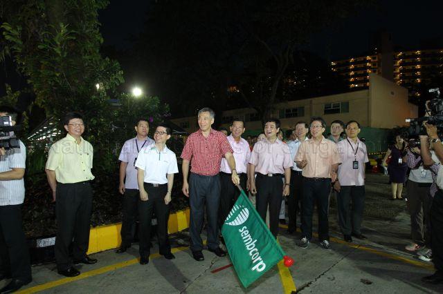 Prime Minister Lee Hsien Loong flagging off trucks making