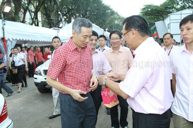 Prime Minister Lee Hsien Loong being presented with mandarin