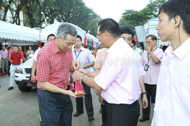 Prime Minister Lee Hsien Loong being presented with mandarin