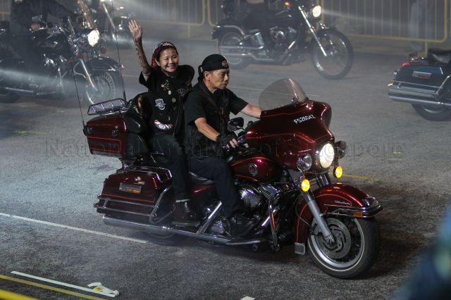 Entourage of Harley-Davidson motorcycles and vintage cars at