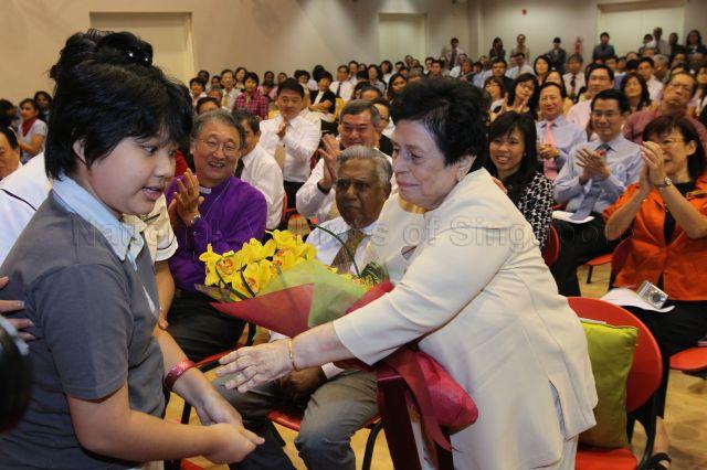 Mrs S R Nathan, wife of the President, being presented with